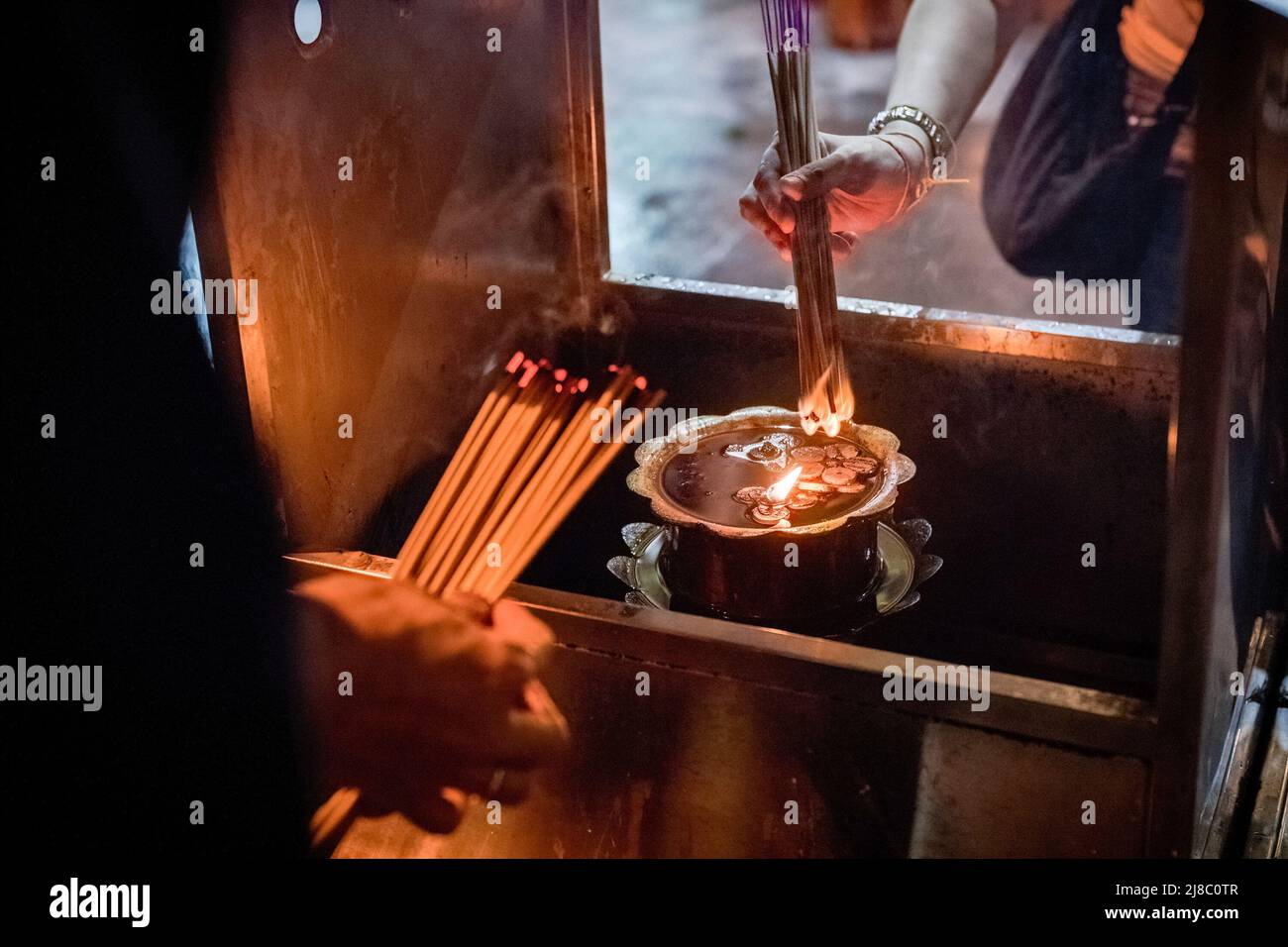 Buddhist devotees are seen burning 'joss sticks' to perform religious ...