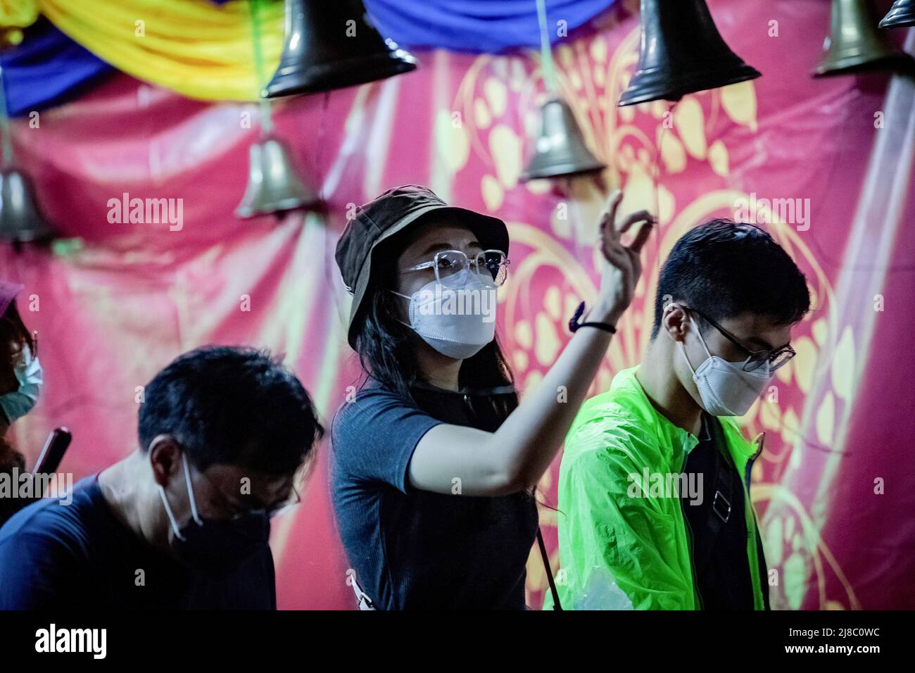 Buddhist devotees are seen ringing the 'Baby Buddha' bells during a ...