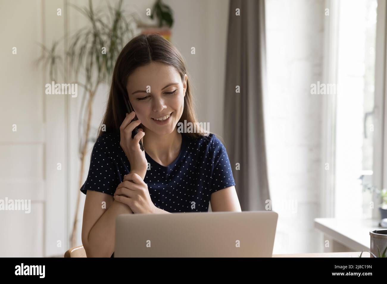 Happy freelance worker woman answering telephone call in home office ...