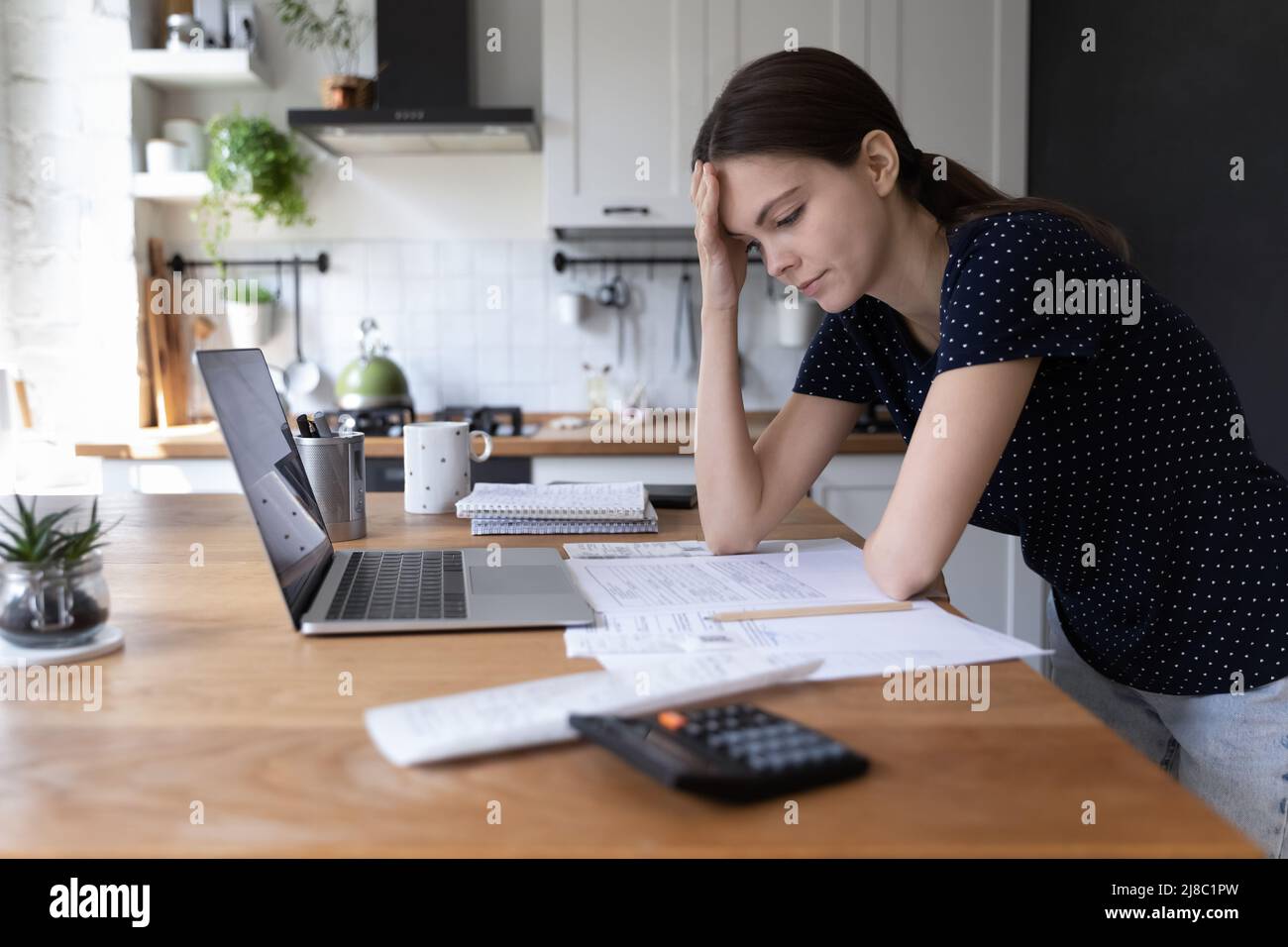 Concerned young woman thinking over domestic paperwork Stock Photo - Alamy