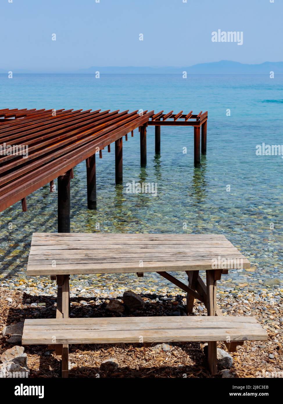Wooden table and bench on the seashore. Handmade picnic table near the ...