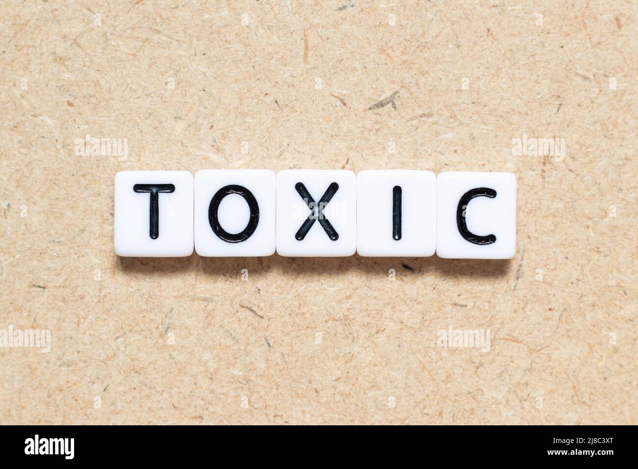 White tile alphabet letter with word toxic on wood background Stock ...