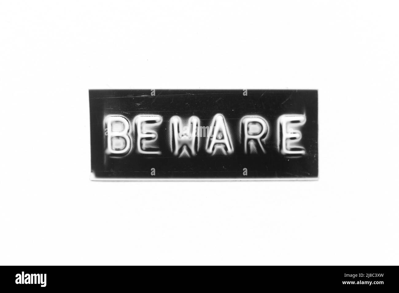 Black color banner that have embossed letter with word beware on white ...
