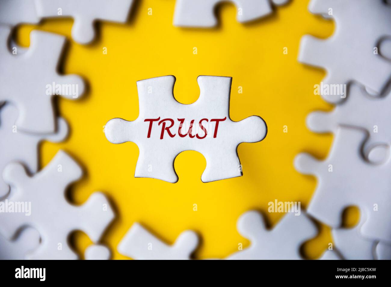 Trust text on jigsaw puzzle with yellow background - Trust concept in ...