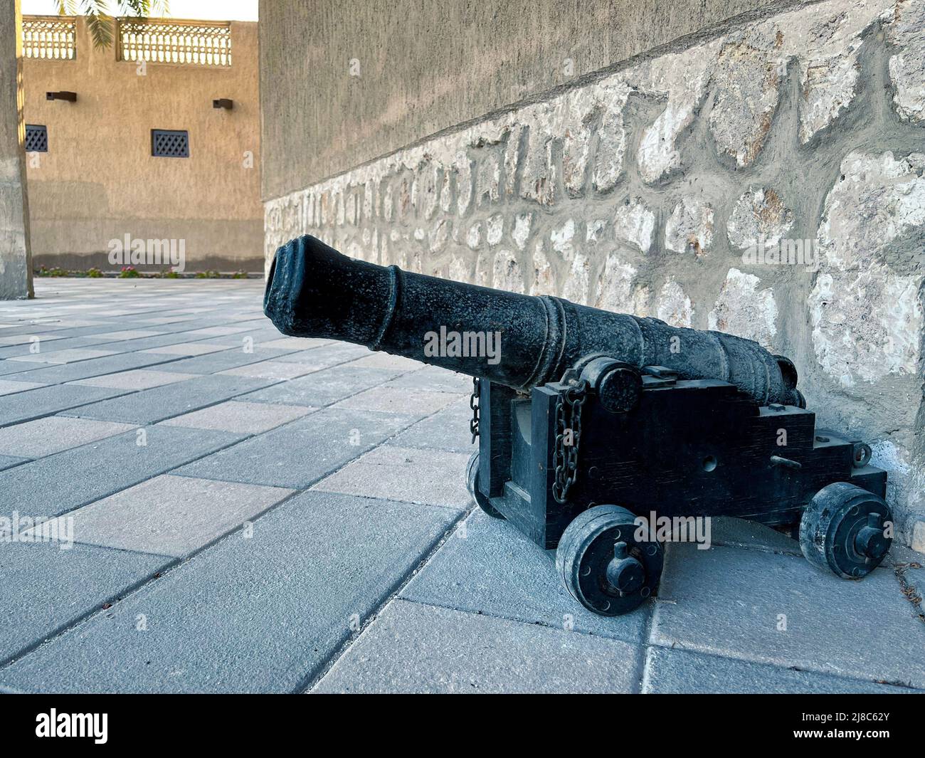 a small antique cannon on wheels stands on the ground in the Old Town ...