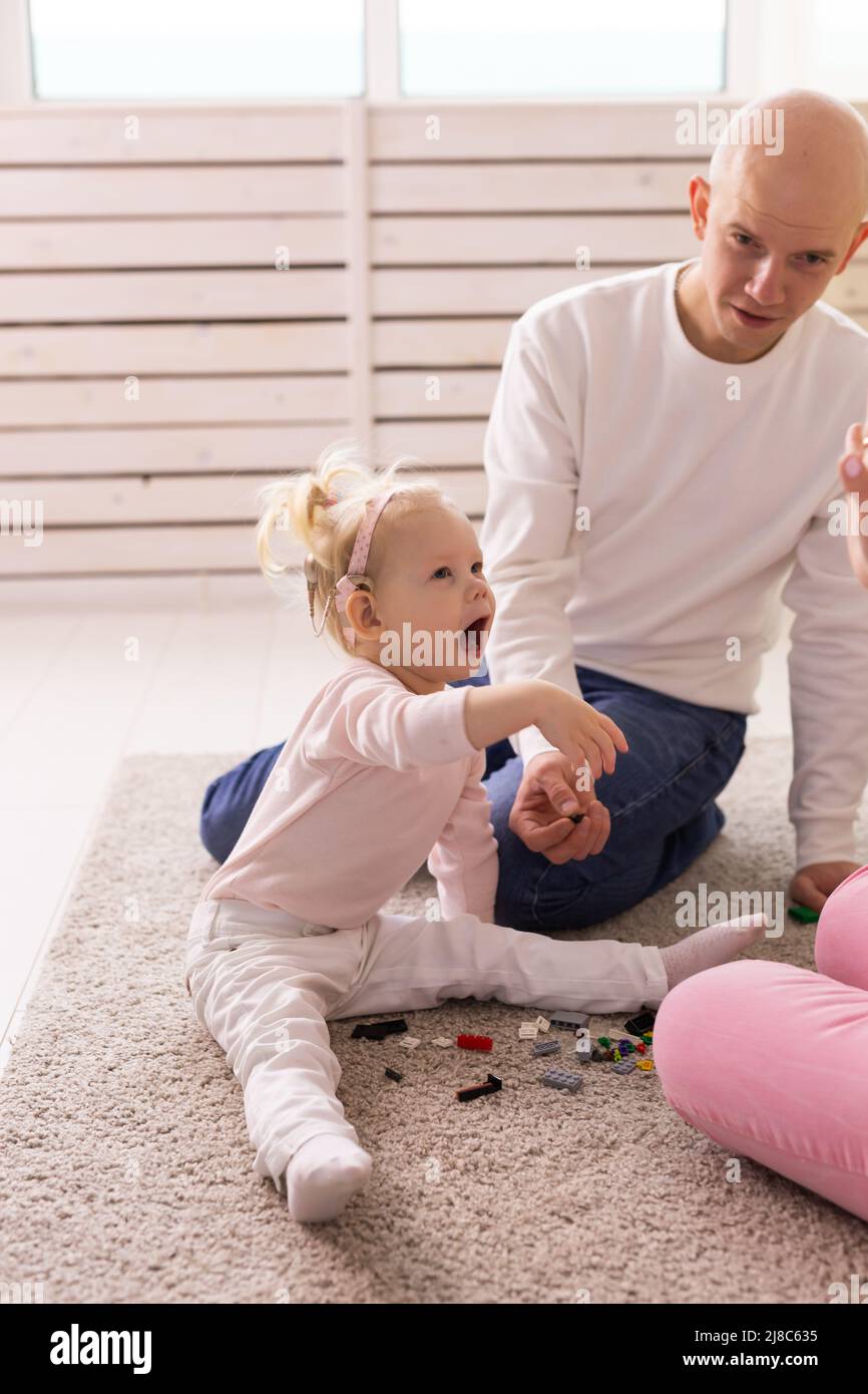 Happy child girl with cochlear implant having fun with her father ...