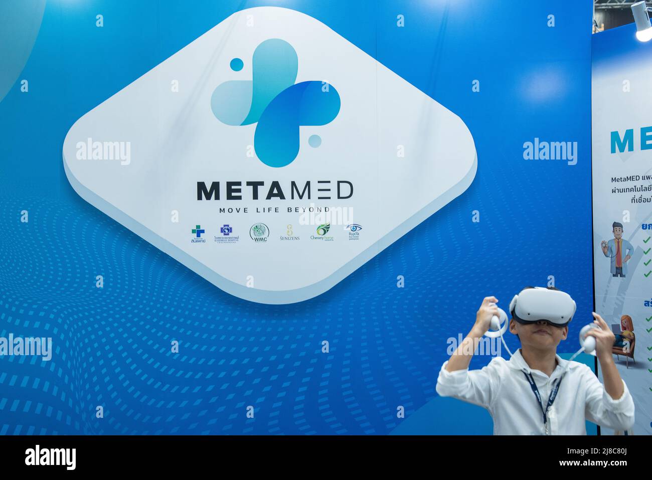 A kid try to use a Virtual Reality (VR) at "Metamed" booth during Thailand Crypto Expo 2022 at ...