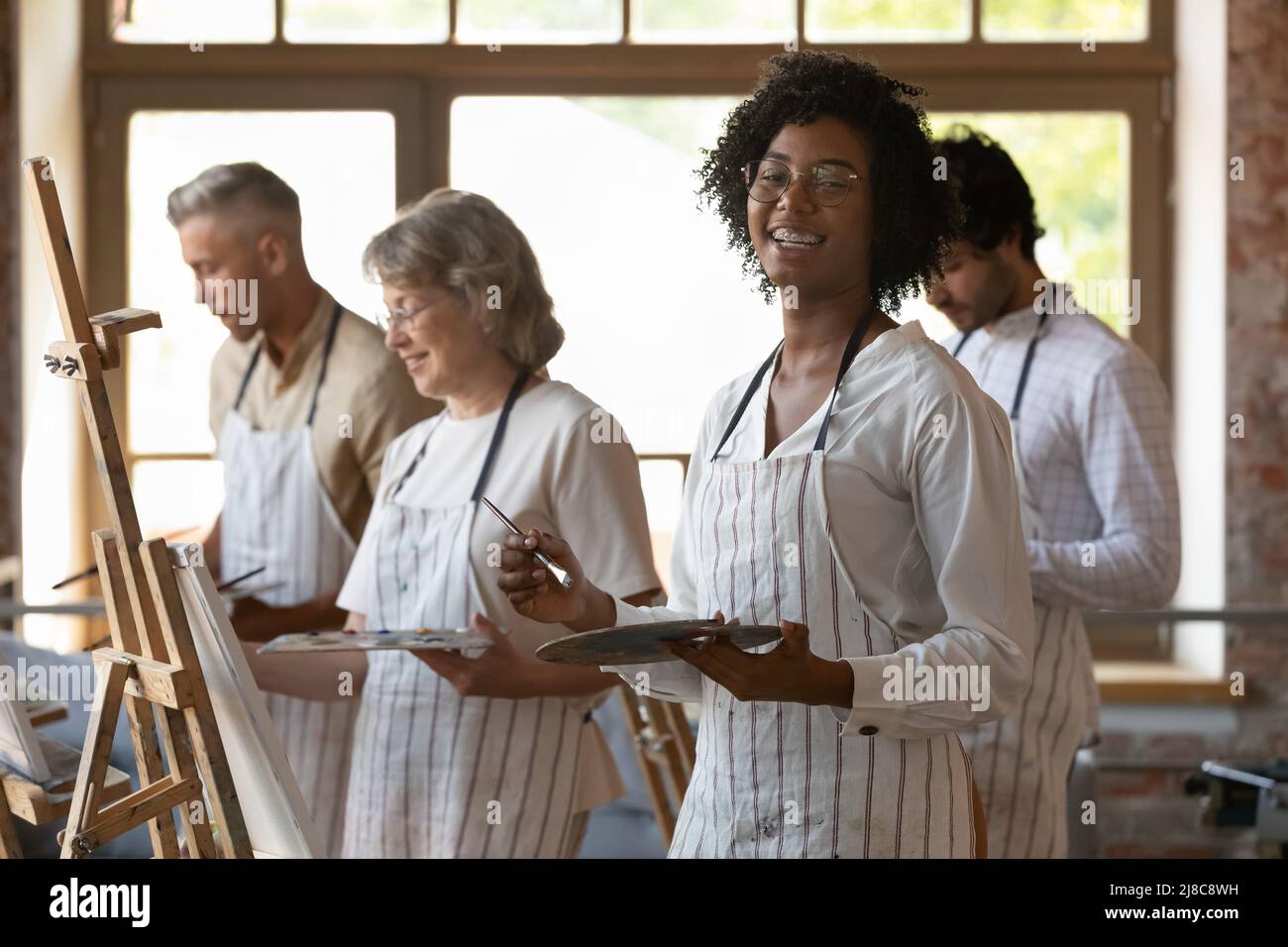 African woman engaged in art-class, pose smile look at camera Stock ...