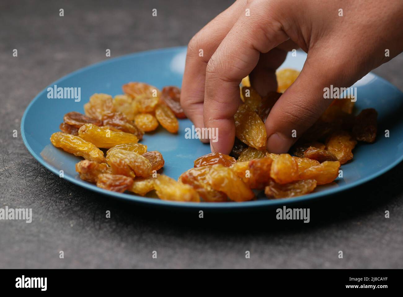 hand pick big size raisin on hand close up Stock Photo - Alamy