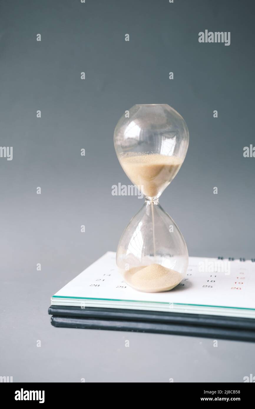 hourglass on a calendar, and flowing through the bulb of sandglass ...
