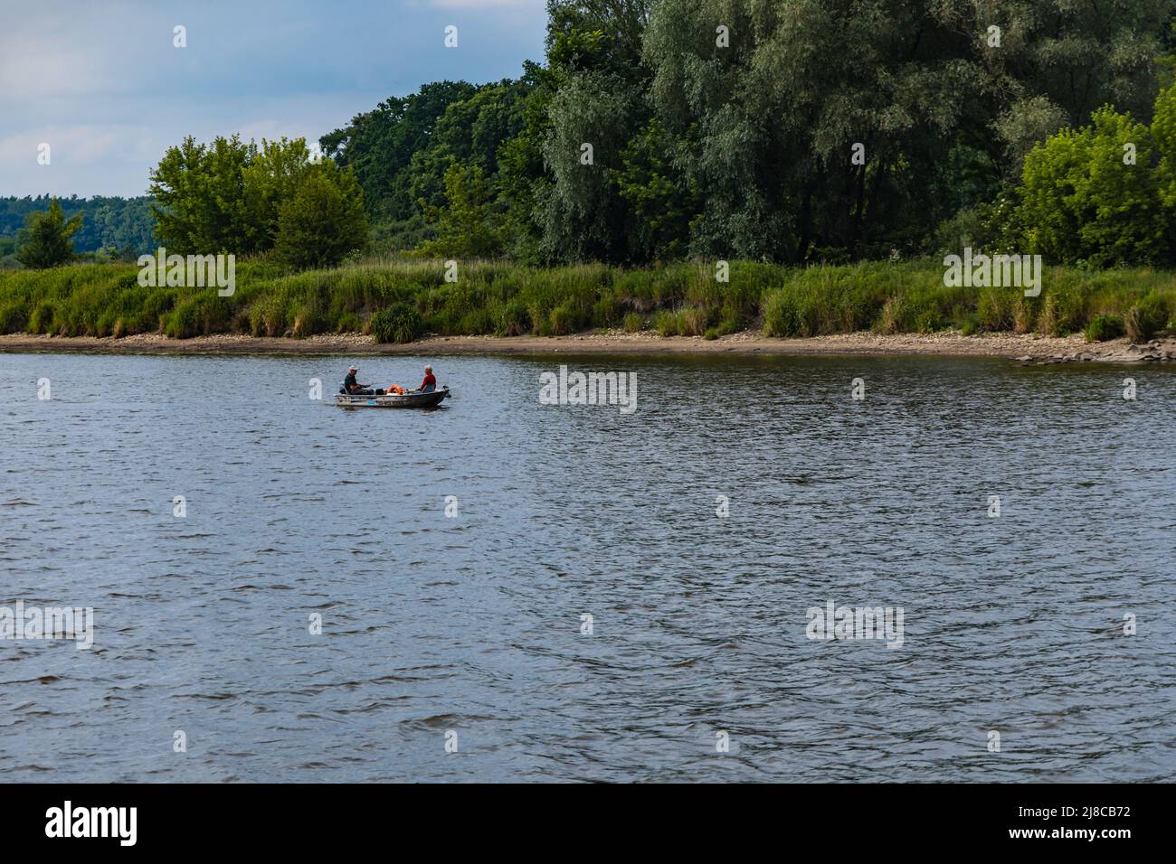 Two people swimming in small boat through river Stock Photo - Alamy