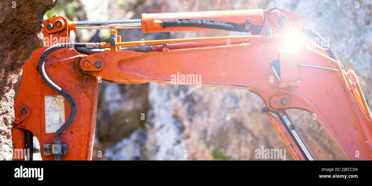 Red Excavators hydraulic hand between rocks Stock Photo - Alamy