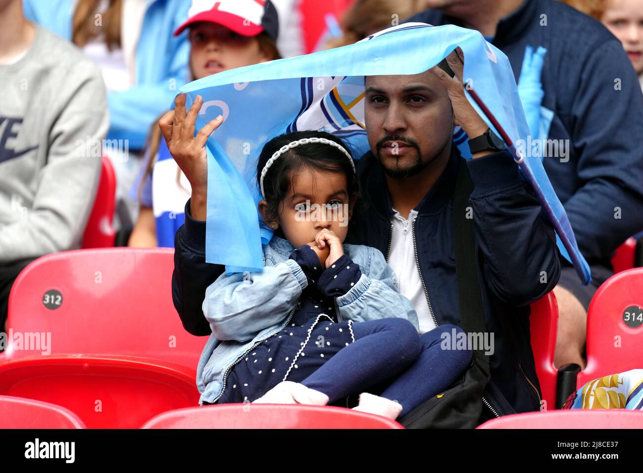 Manchester City fans shield themselves from the rain before the ...