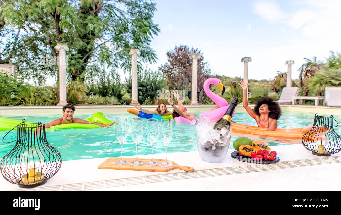 summer swimming pool party! happy multiracial group of friends relaxing ...