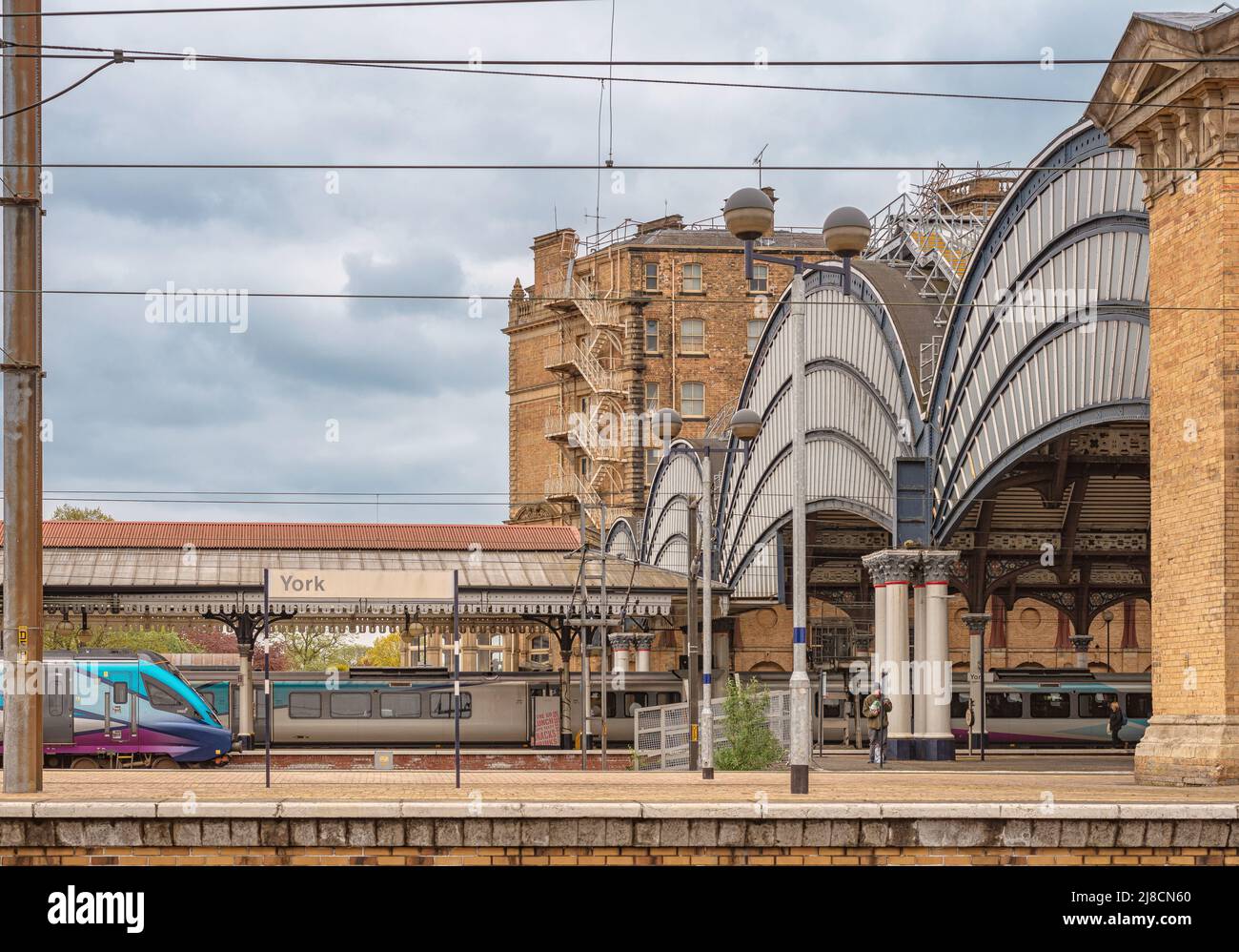 Historic arches are over the entrance to a railway station. Trains ...
