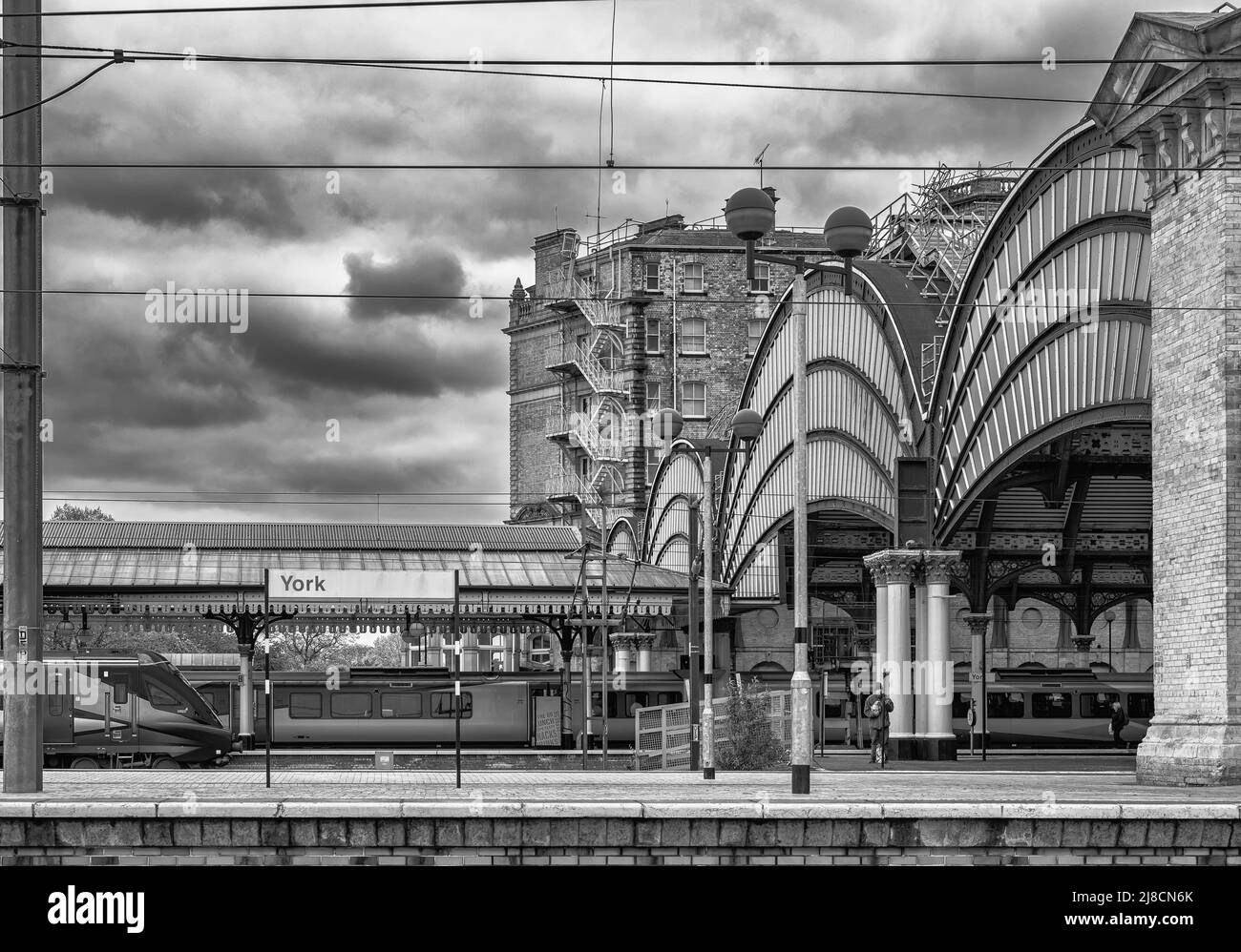 Historic arches are over the entrance to a railway station. Trains ...