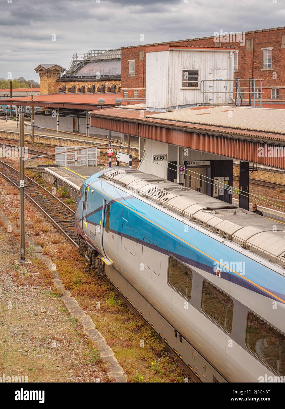 Overhead view of a train at a railway station. The metal canopies are ...