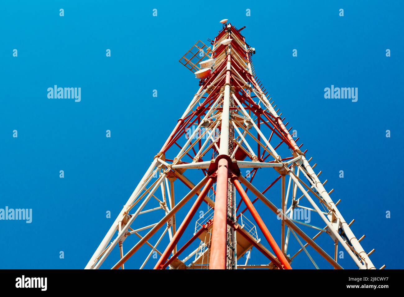 The communication tower stands against the sky with a bottom-up view ...