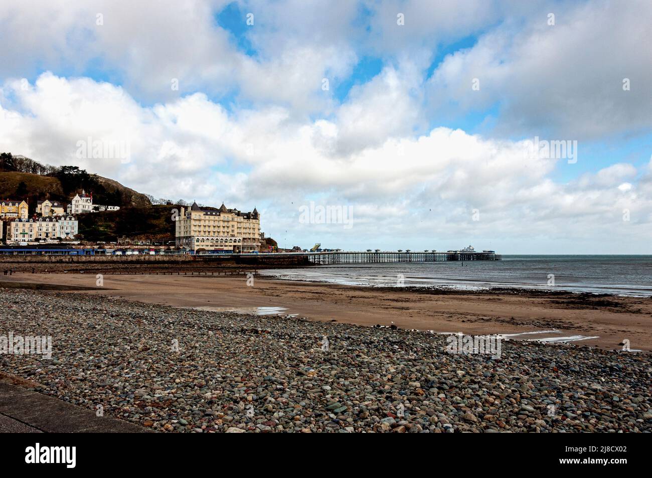 Hotels nestle beneath the tree covered face of the Great Orme cliff but ...
