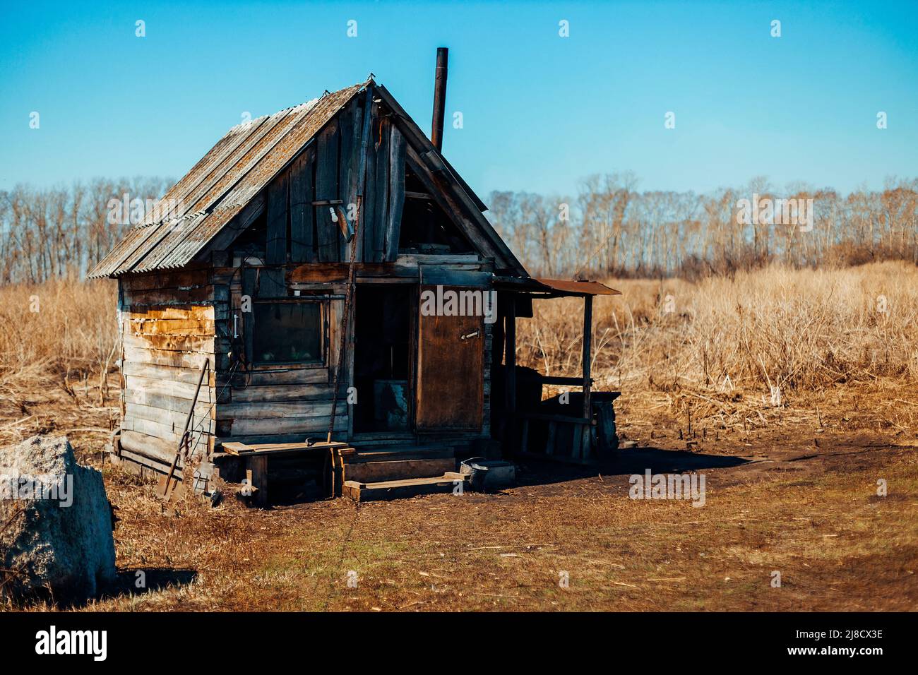 Old crumbling wooden house stands alone in steppe. Dilapidated ...