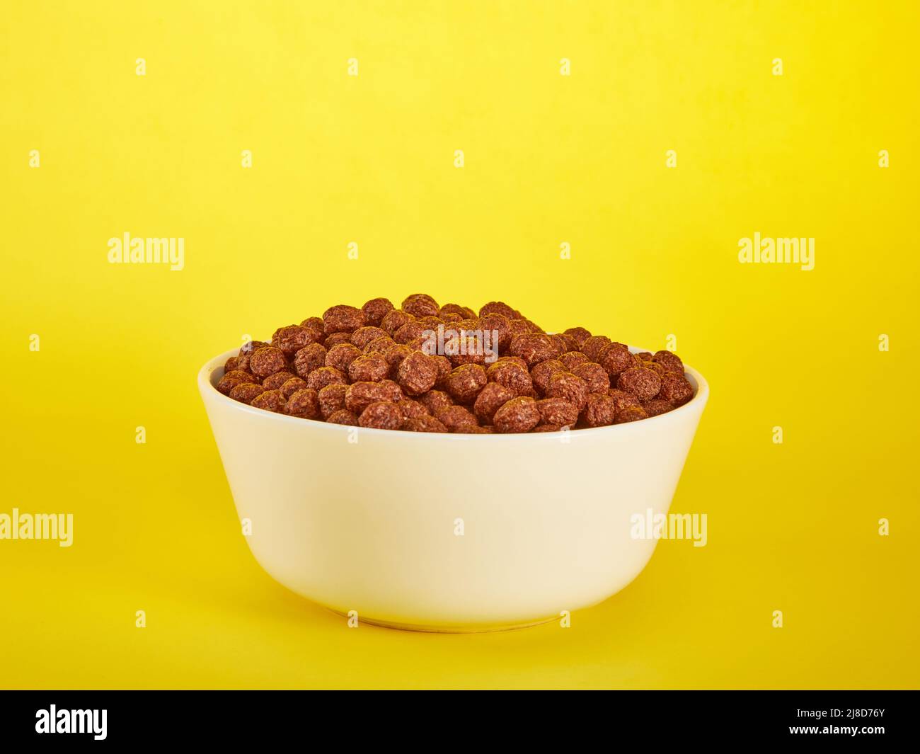 Chocolate Corn balls in bowl over yellow background Stock Photo - Alamy