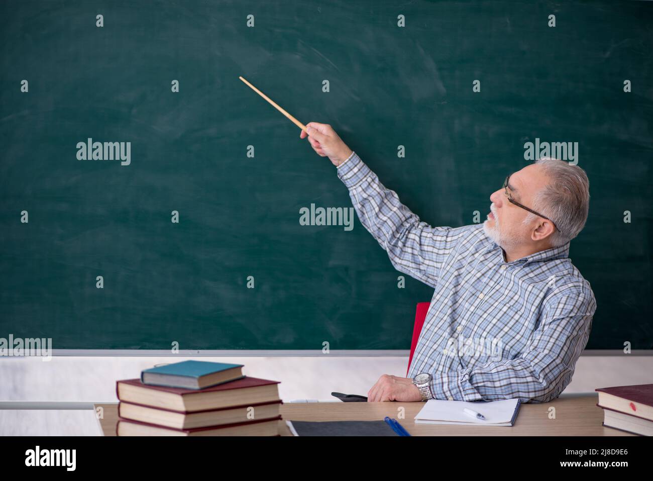 Aged male teacher in the classroom Stock Photo - Alamy