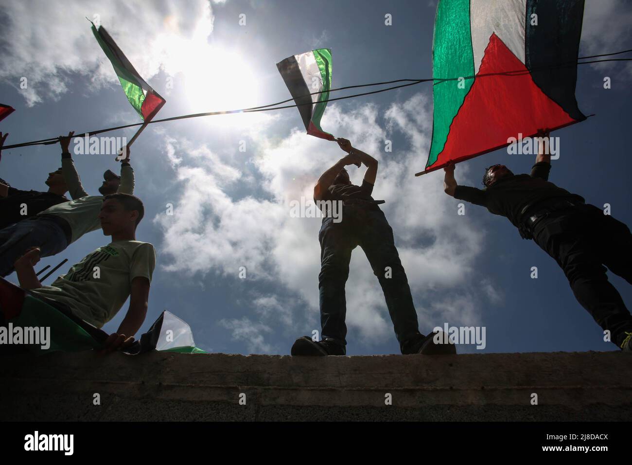 Palestinian demonstrators wave flags during a rally marking the 74th ...