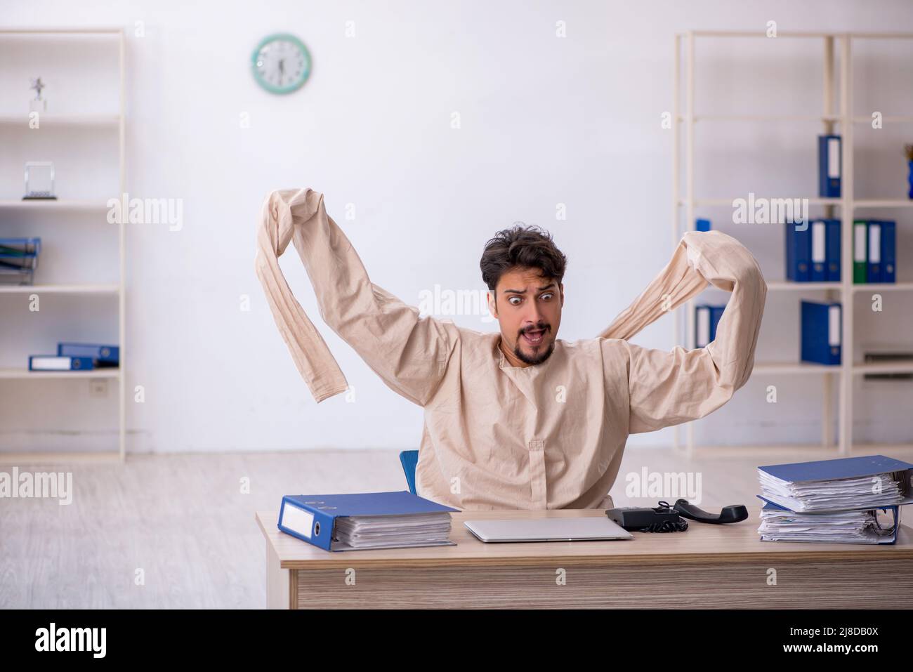 Crazy young male employee in straitjacket at the office Stock Photo - Alamy