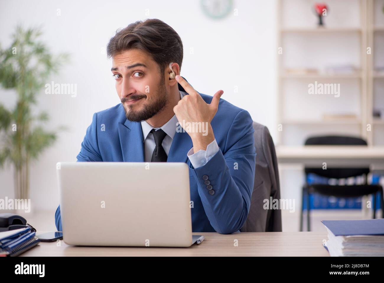 Deaf businessman employee using hearing aid in the office Stock Photo ...