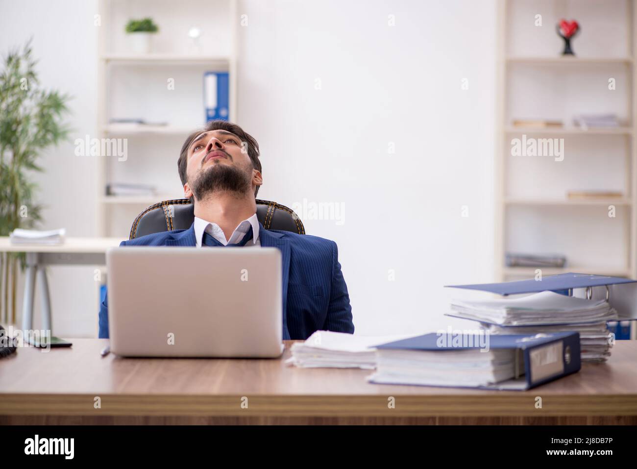 Young businessman employee and too much work in the office Stock Photo ...