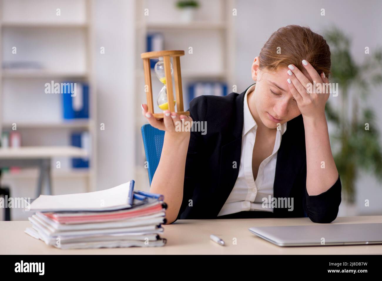 Female employee in time management concept Stock Photo - Alamy