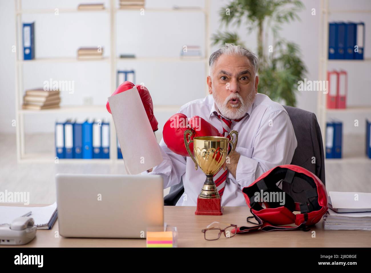 Old businessman employee boxer being awarded with golden cup Stock ...