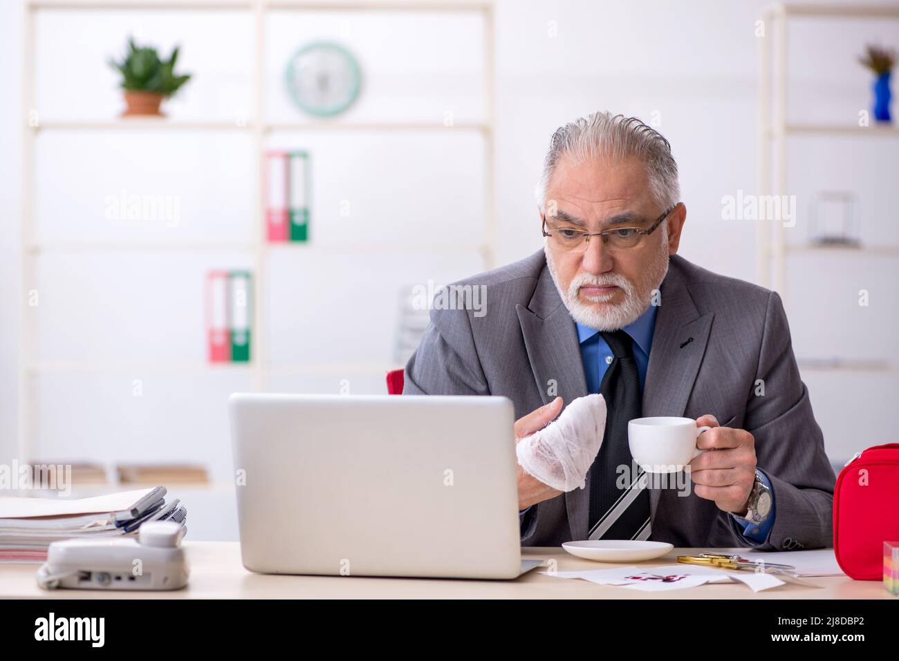 Old businessman employee cutting his hand at workplace Stock Photo - Alamy