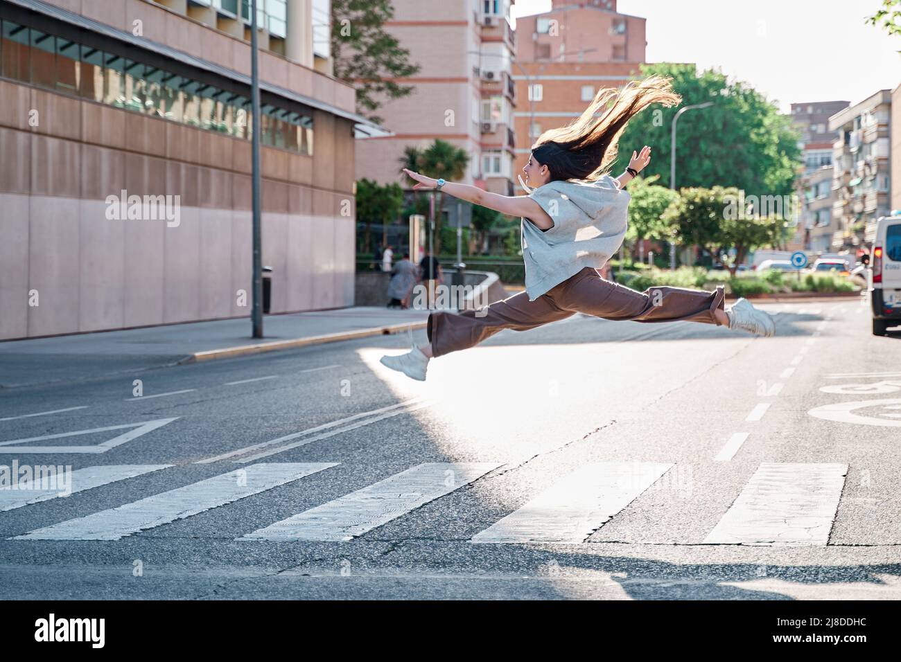 Young gymnastics and dance enthusiast performing a perfect split jump ...