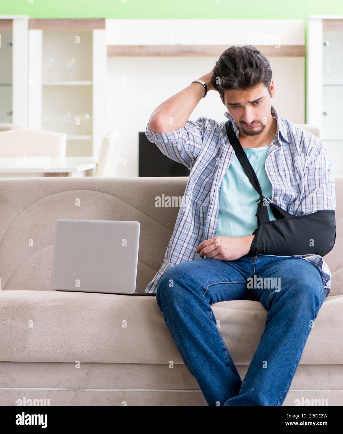 The young student man with hand injury sitting on the sofa Stock Photo ...