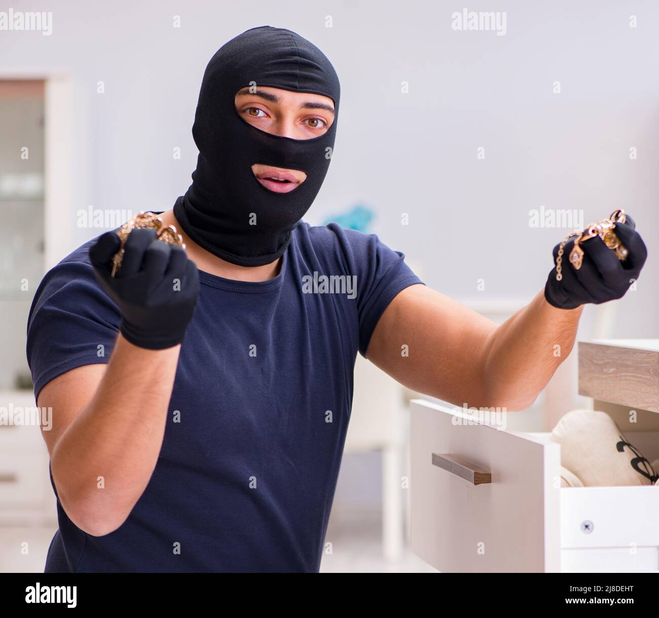 The robber wearing balaclava stealing valuable things Stock Photo - Alamy