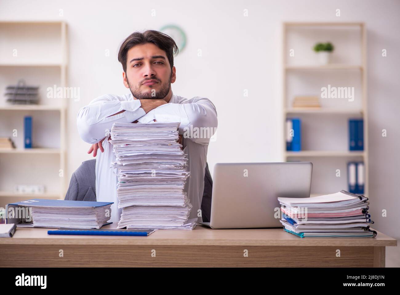 Young male employee unhappy with excessive work at workplace Stock ...