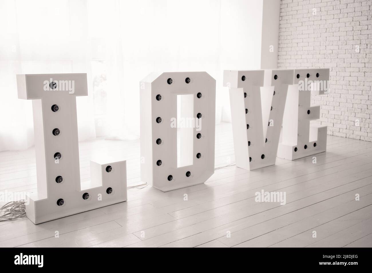 an inscription of letters love with light bulbs in the loft room Stock ...