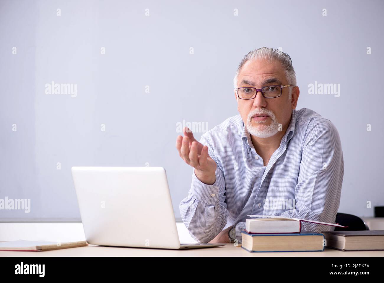 Old teacher in front of whiteboard Stock Photo - Alamy