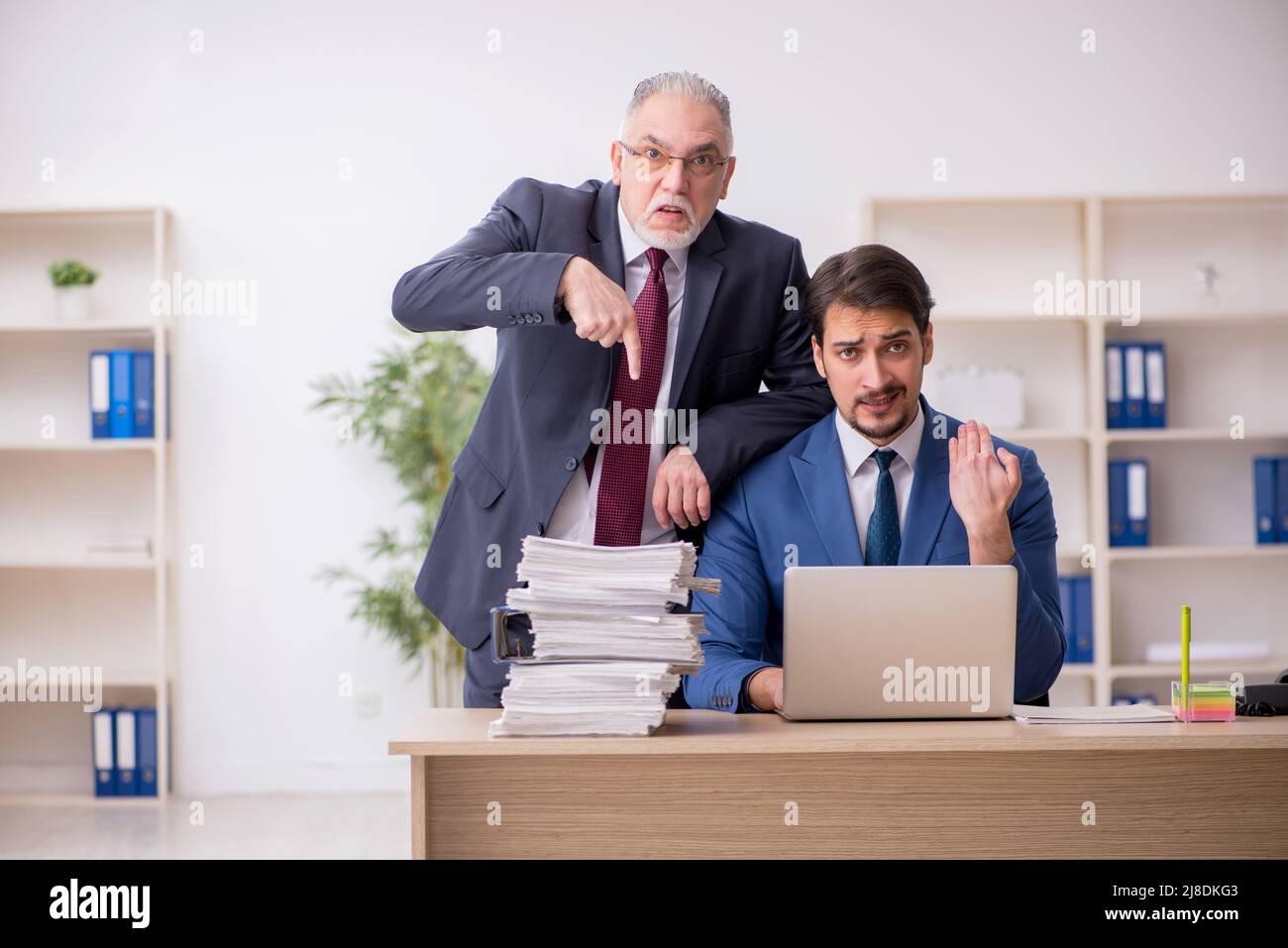 Old boss and young employee in bullying concept Stock Photo - Alamy