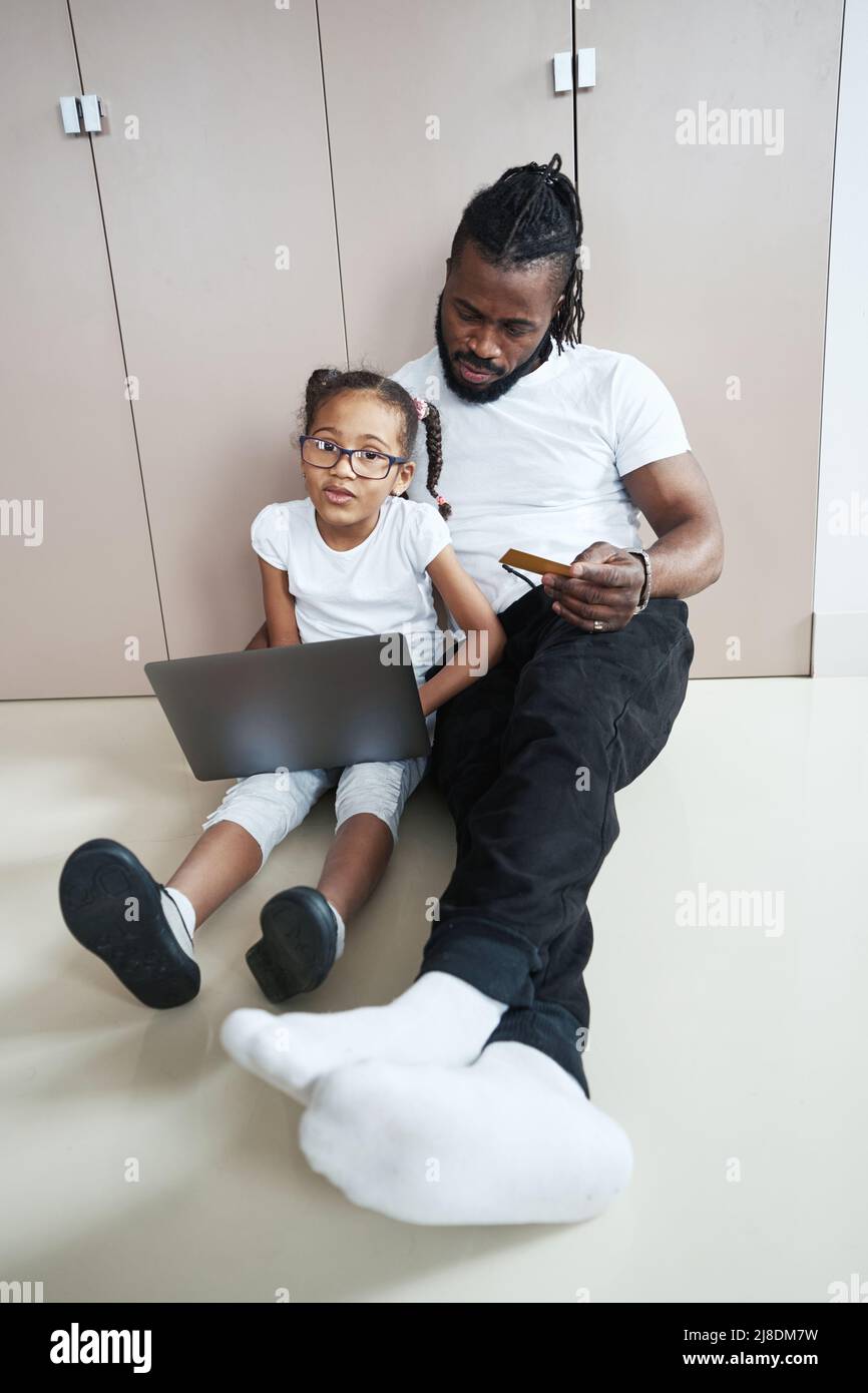 Daughter with father use laptop on the floor in room Stock Photo - Alamy