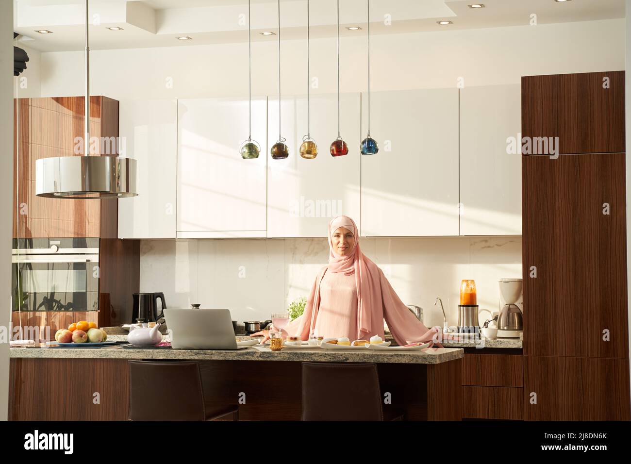 Arab Islamic woman standing in kitchen with modern interior Stock Photo ...