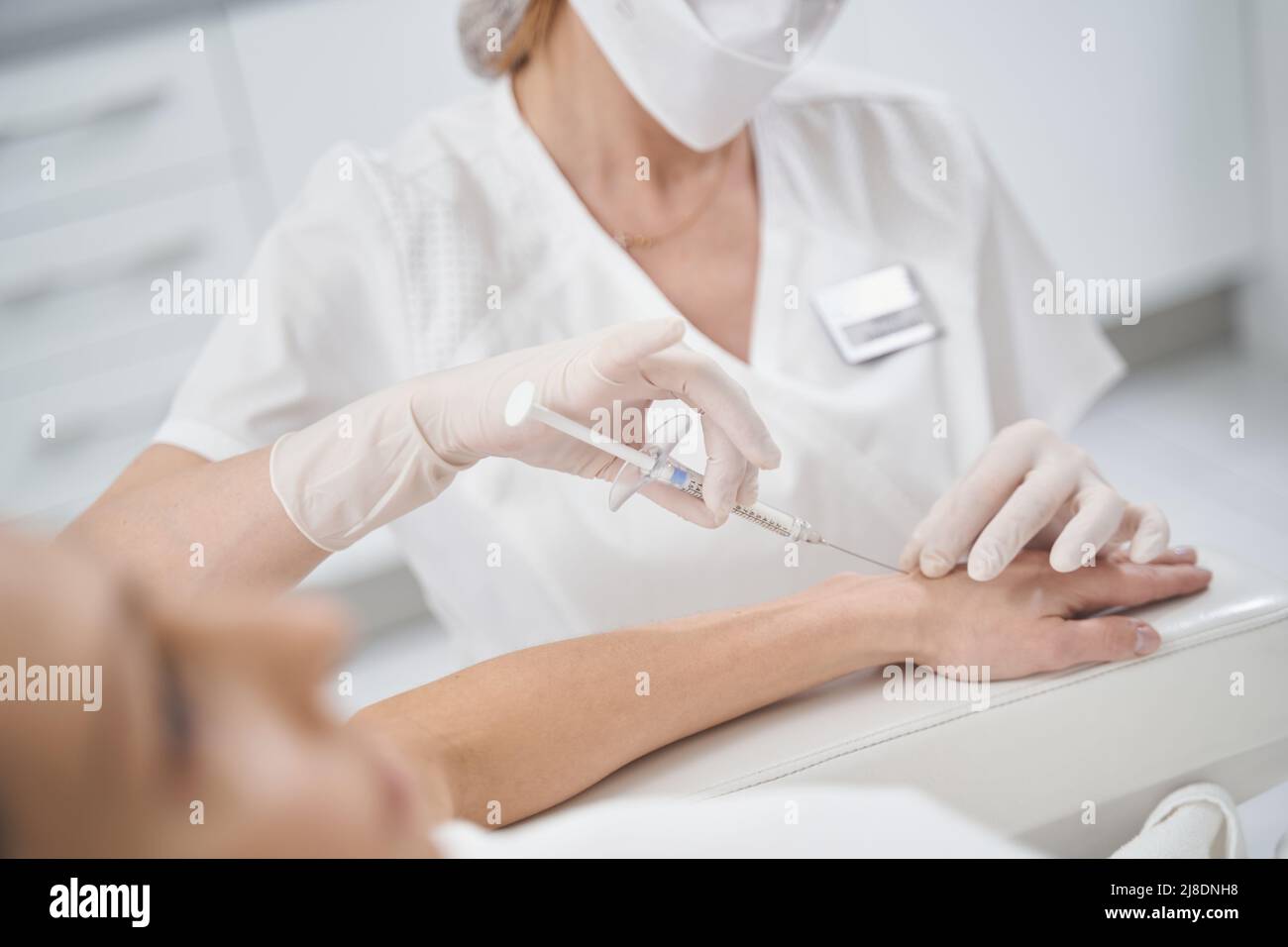 Beauty doctor doing injection into woman arm Stock Photo - Alamy