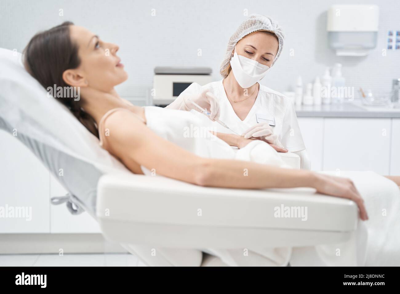 Woman having arm injection procedure in beauty clinic Stock Photo - Alamy