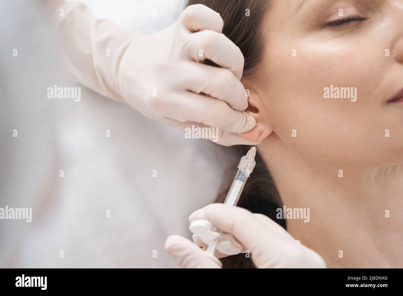 Doctor cosmetologist making beauty injection in woman ear Stock Photo ...