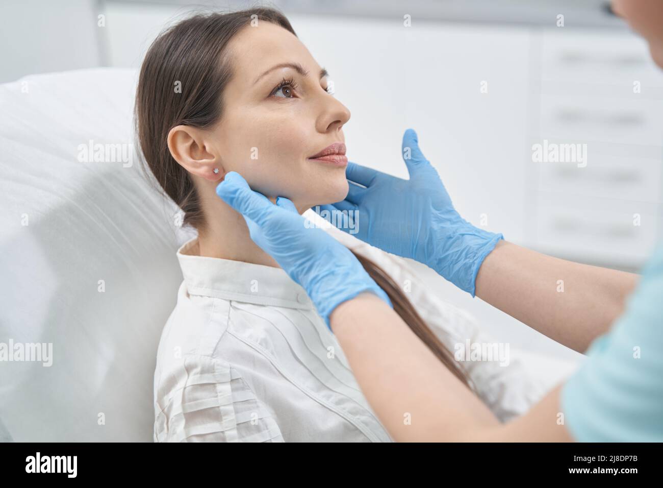 Doctor esthetician checking woman face skin in cosmetology clinic Stock Photo - Alamy