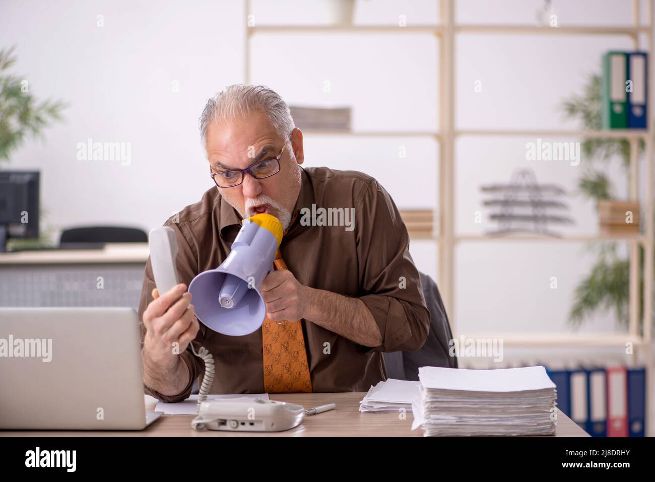 Angry businessman employee holding megaphone in the office Stock Photo ...