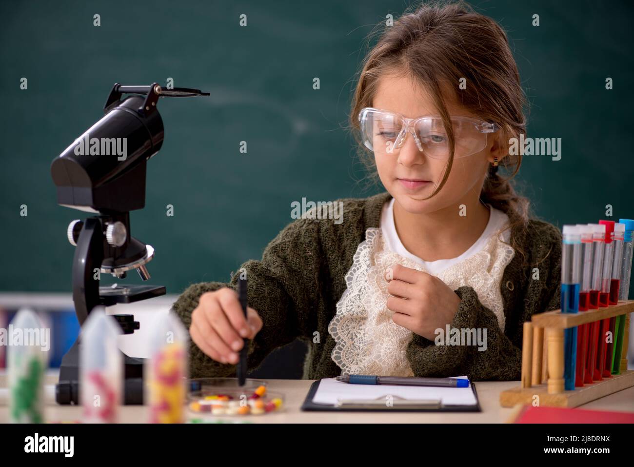 Young small girl chemist in the classroom Stock Photo - Alamy