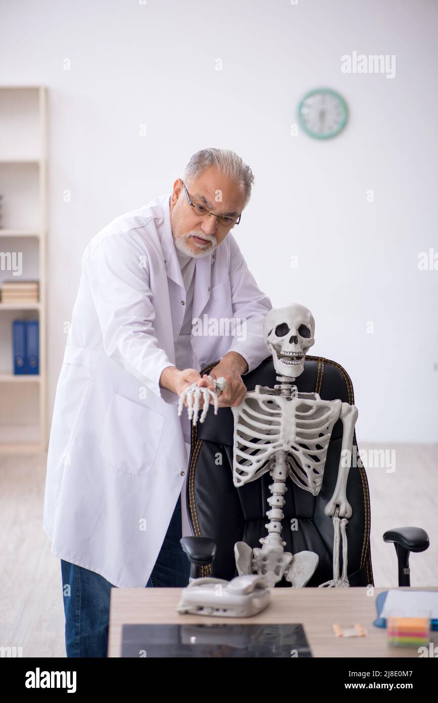 Old doctor with skeleton at the hospital Stock Photo - Alamy