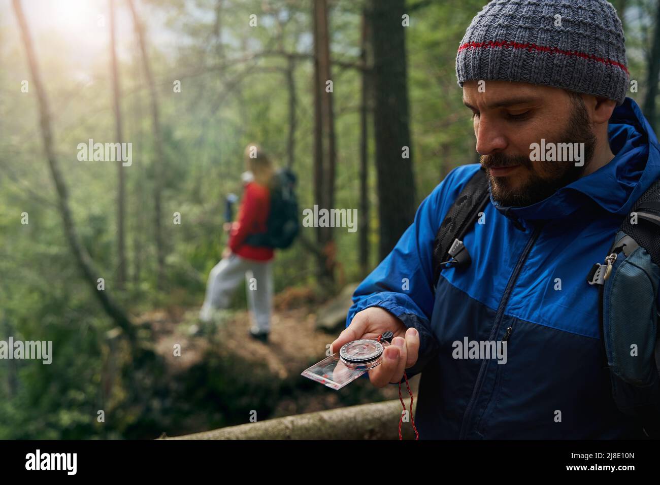 Male tourist using compass for navigation in forest Stock Photo - Alamy